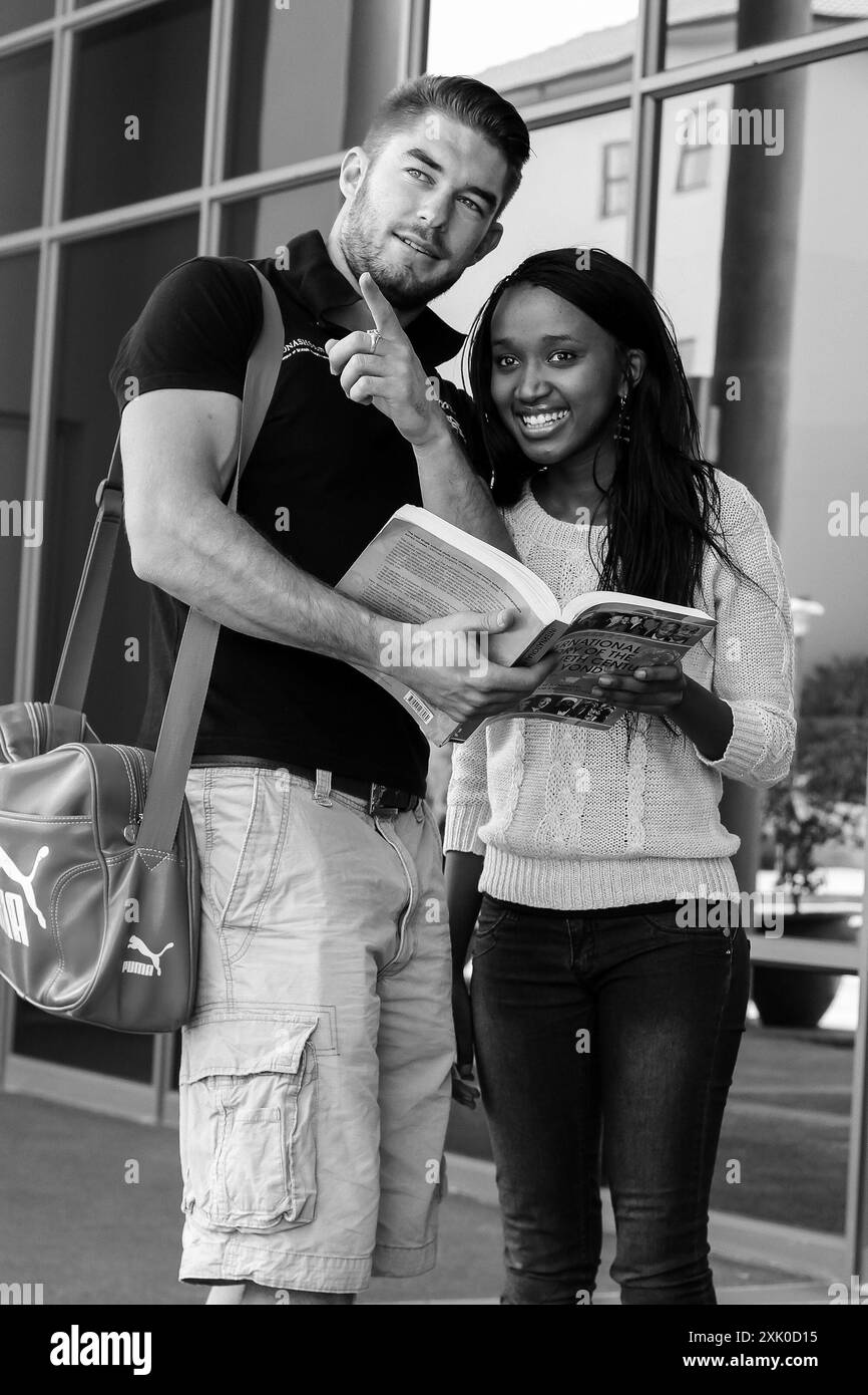 The two college students standing outside a building, reading a book ...