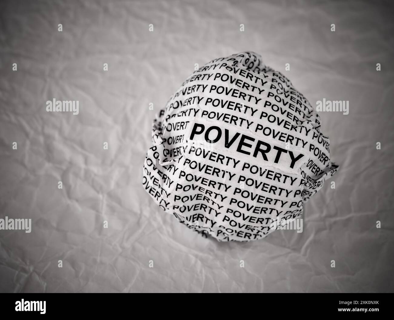 Crumpled paper ball with words Poverty on a crumpled white paper ...