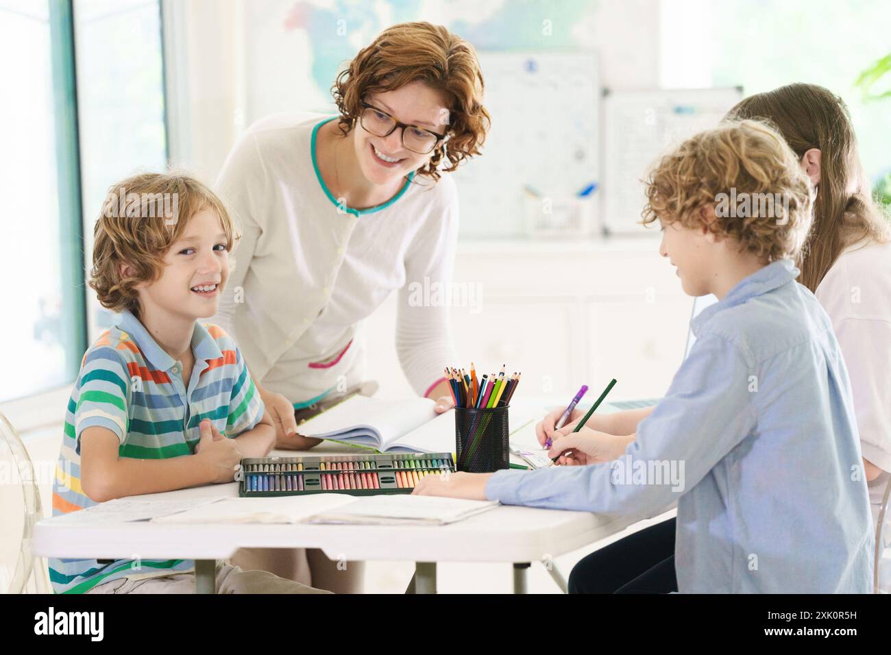 Back to school. Kids and teacher in classroom during math class ...