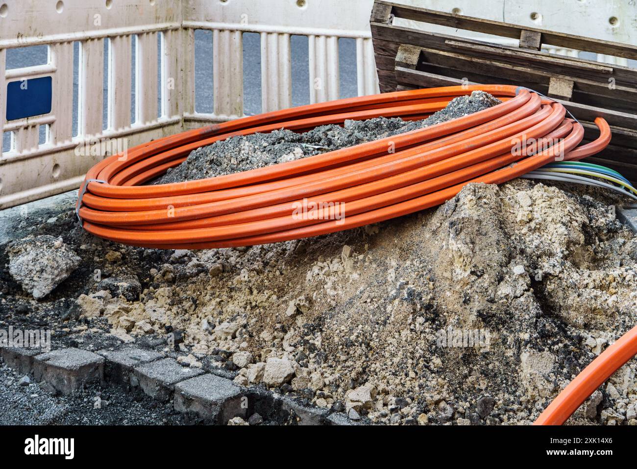 Thick rolled up fiber optic cable on a construction site by the road ...