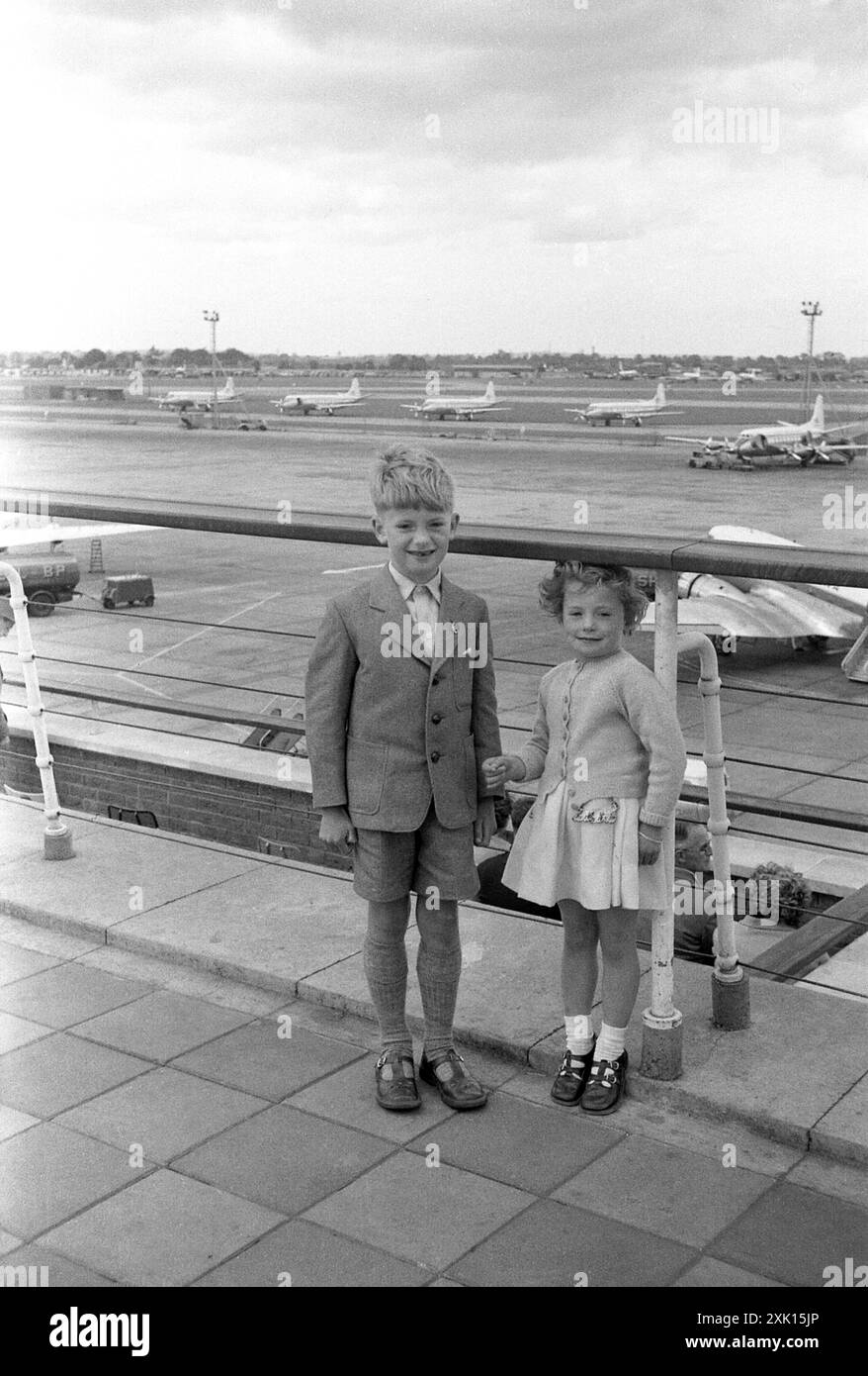 Heathrow, London. 1957 – Two young children posing for a photograph on ...