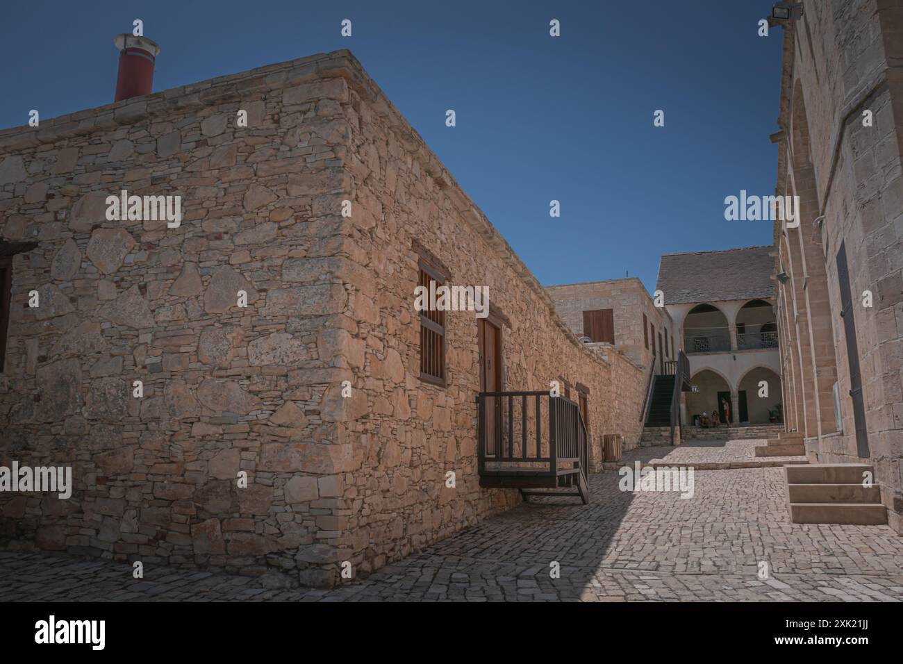 Rustic stone buildings with wooden doors and windows, set along a ...
