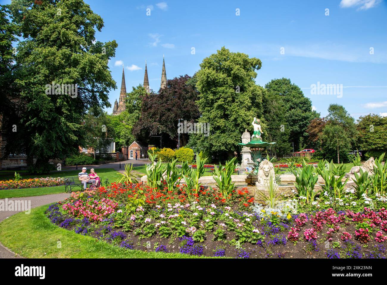 Couple enjoying the summer sunshine in the formal floral flower gardens ...