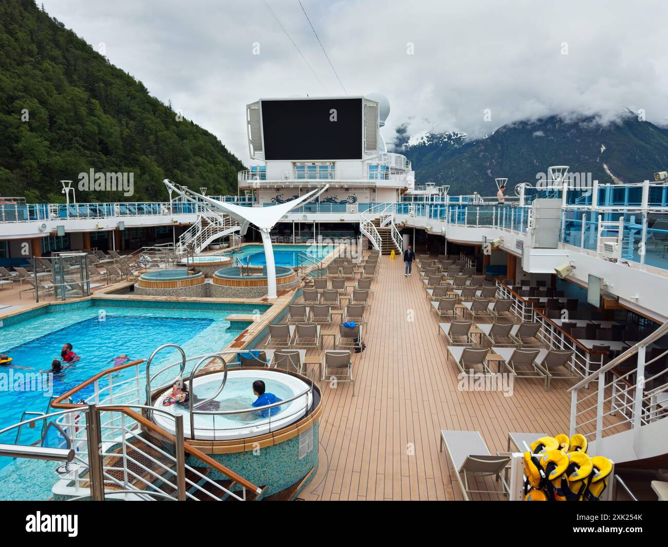 Passengers enjoy the pool deck on the cruise ship Discovery Princess ...