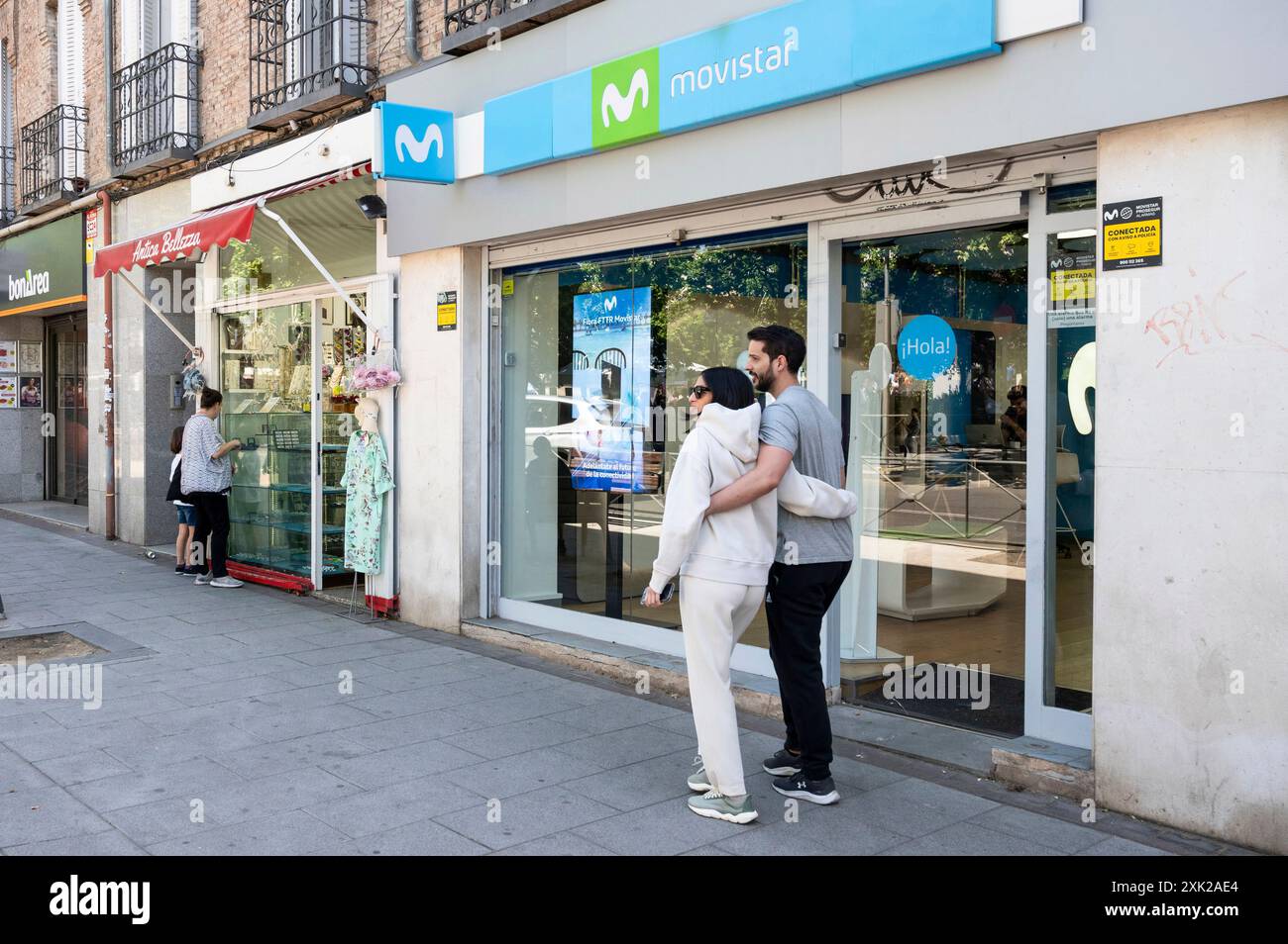A couple walks past a store of Movistar, the Spanish telecommunications ...