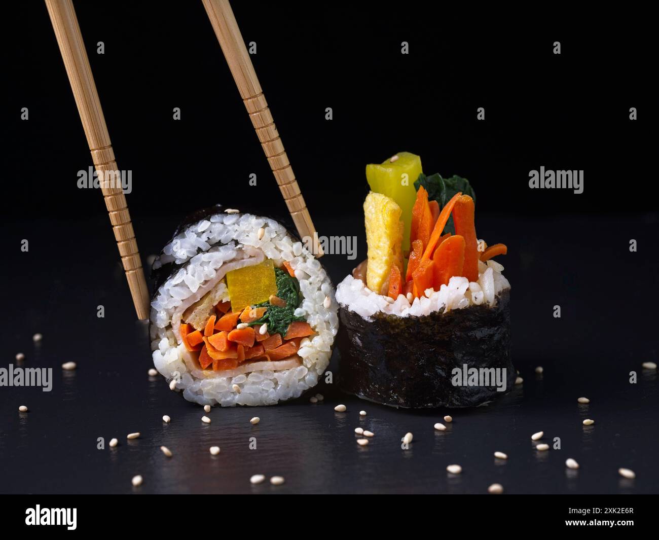 A close up studio photo of grabbing a Korean kimbap slice with a pair ...