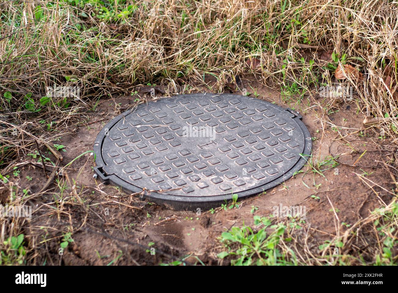 A concrete well with a heavy metal manhole cover. Water well Stock ...
