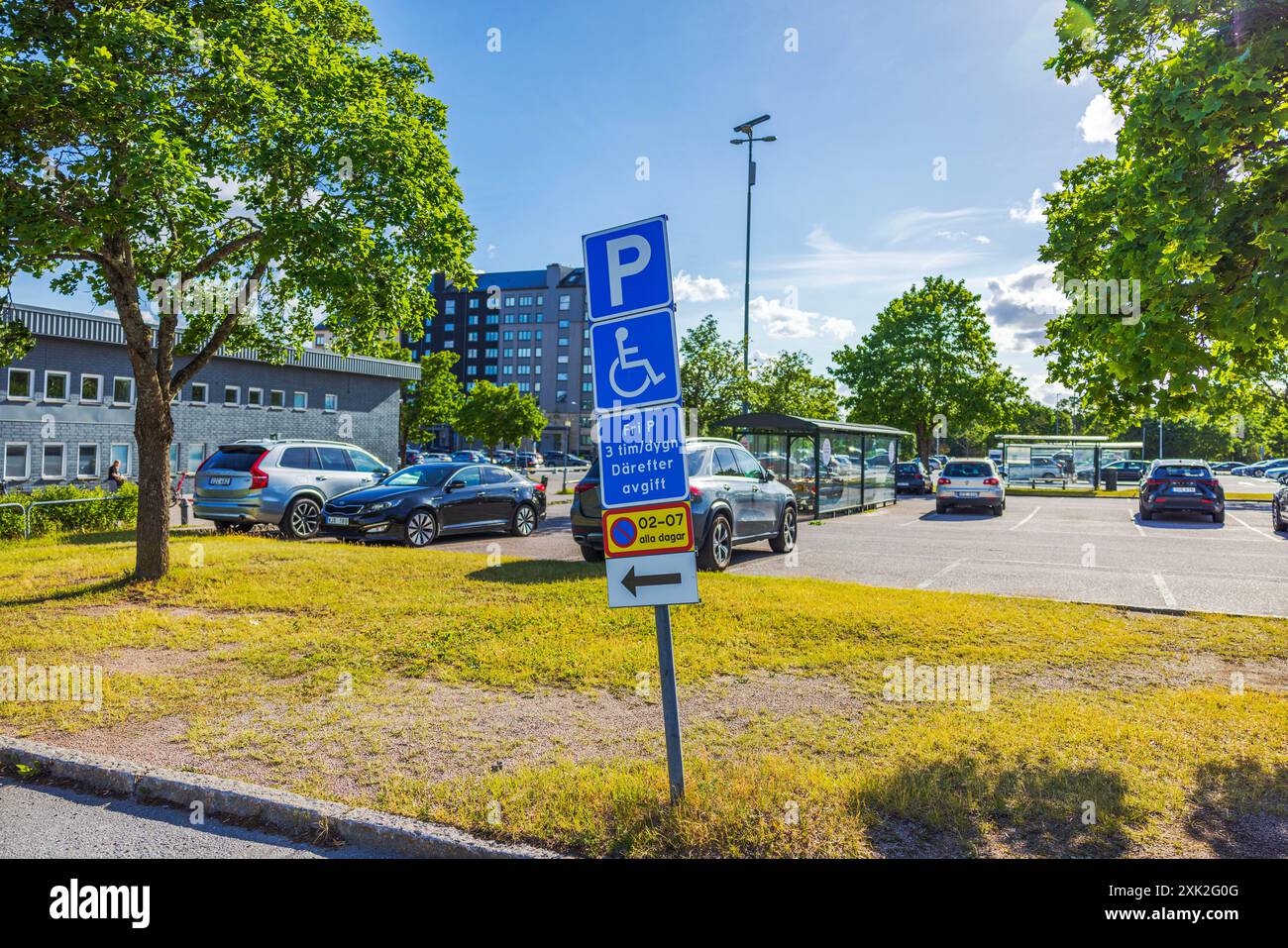 View of handicap parking sign in lot with cars, indicating free parking ...