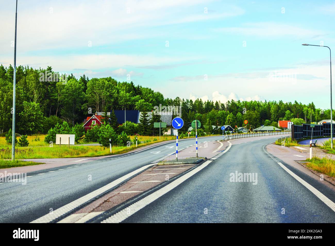 Beautiful view of highway flanked by forests on one side and tall noise ...