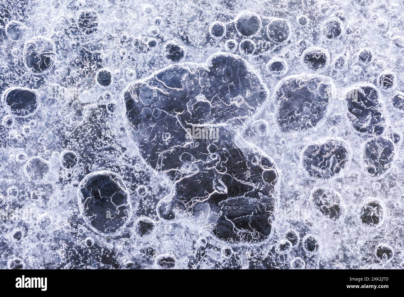 A close-up view of intriguing patterns formed by ice bubbles trapped ...