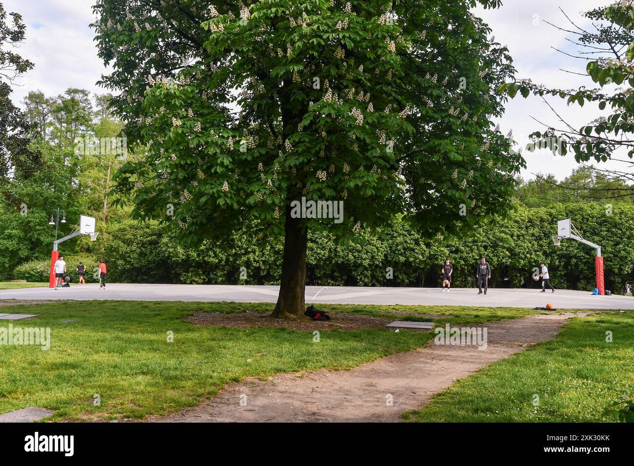 Guys playing in the basketball court of the Sempione Park in spring ...