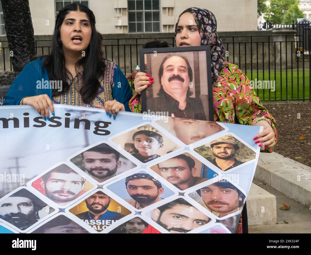 London, UK. 20 July 2024. Women hold a picture of Mir Taj Muhammad ...