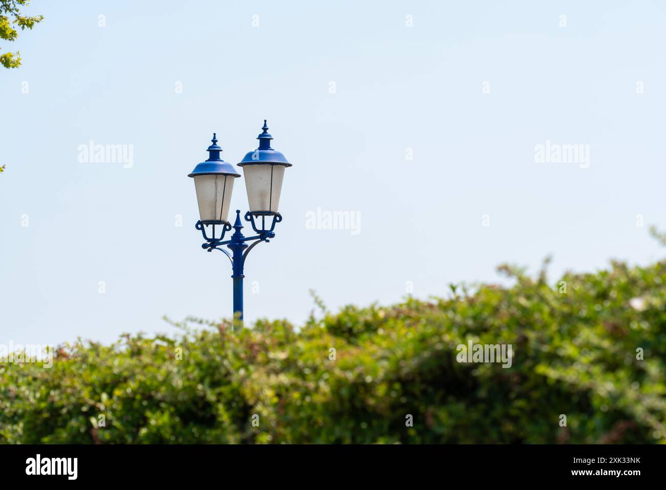 Old patinated blue lamp post above a hedge Stock Photo - Alamy
