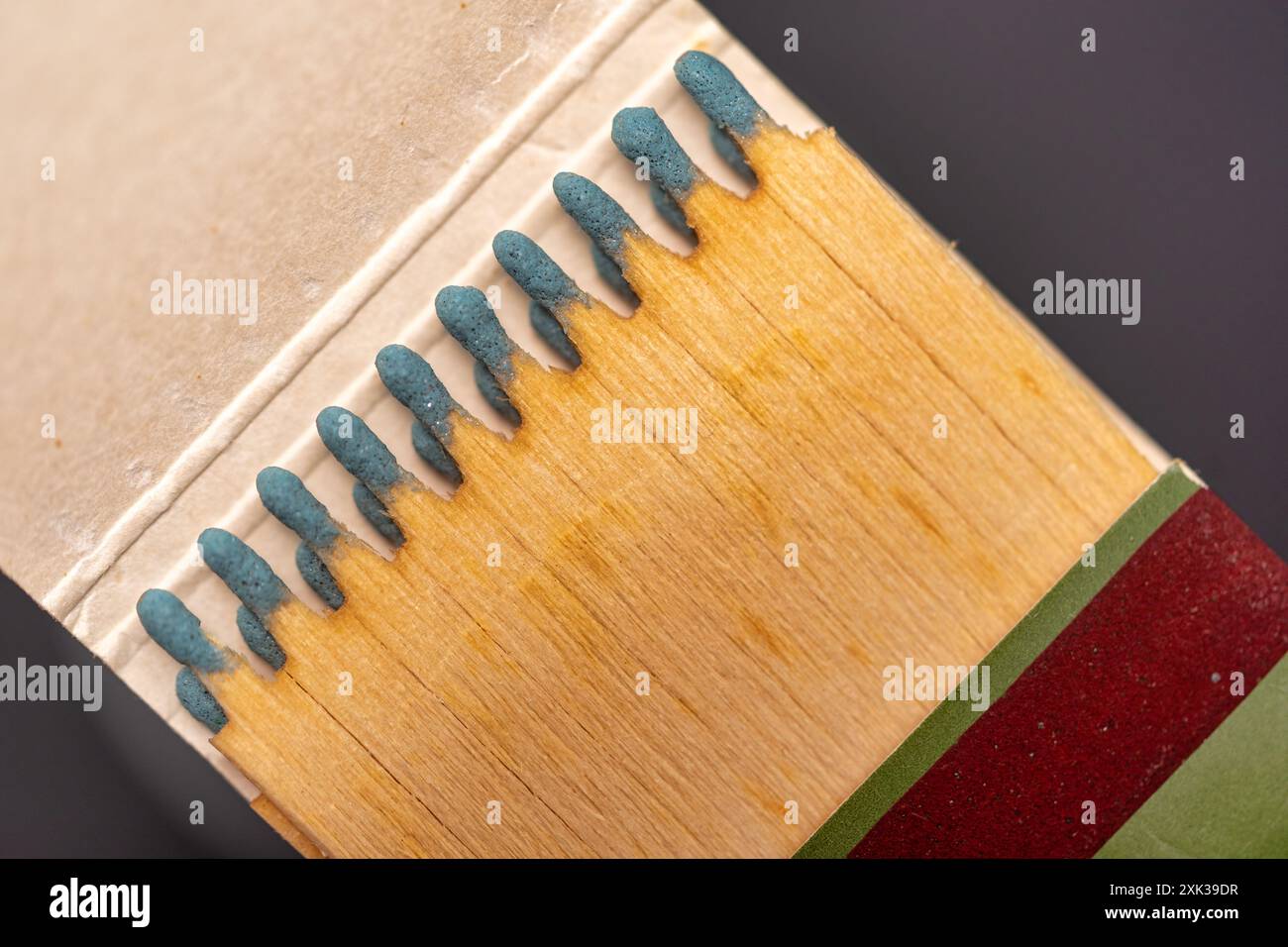 A blue match head focused on a blurred background of blue cardboard ...