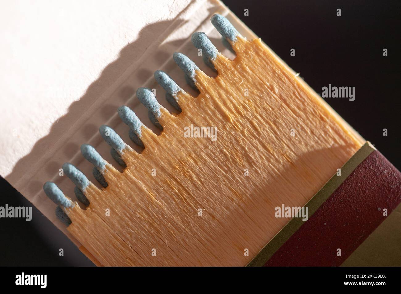 A blue match head focused on a blurred background of blue cardboard ...