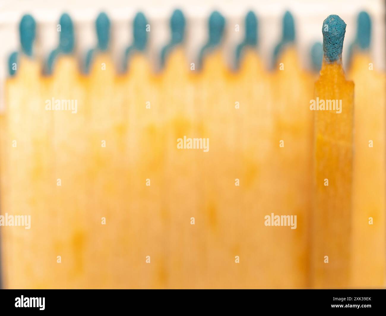 A blue match head focused on a blurred background of blue cardboard ...