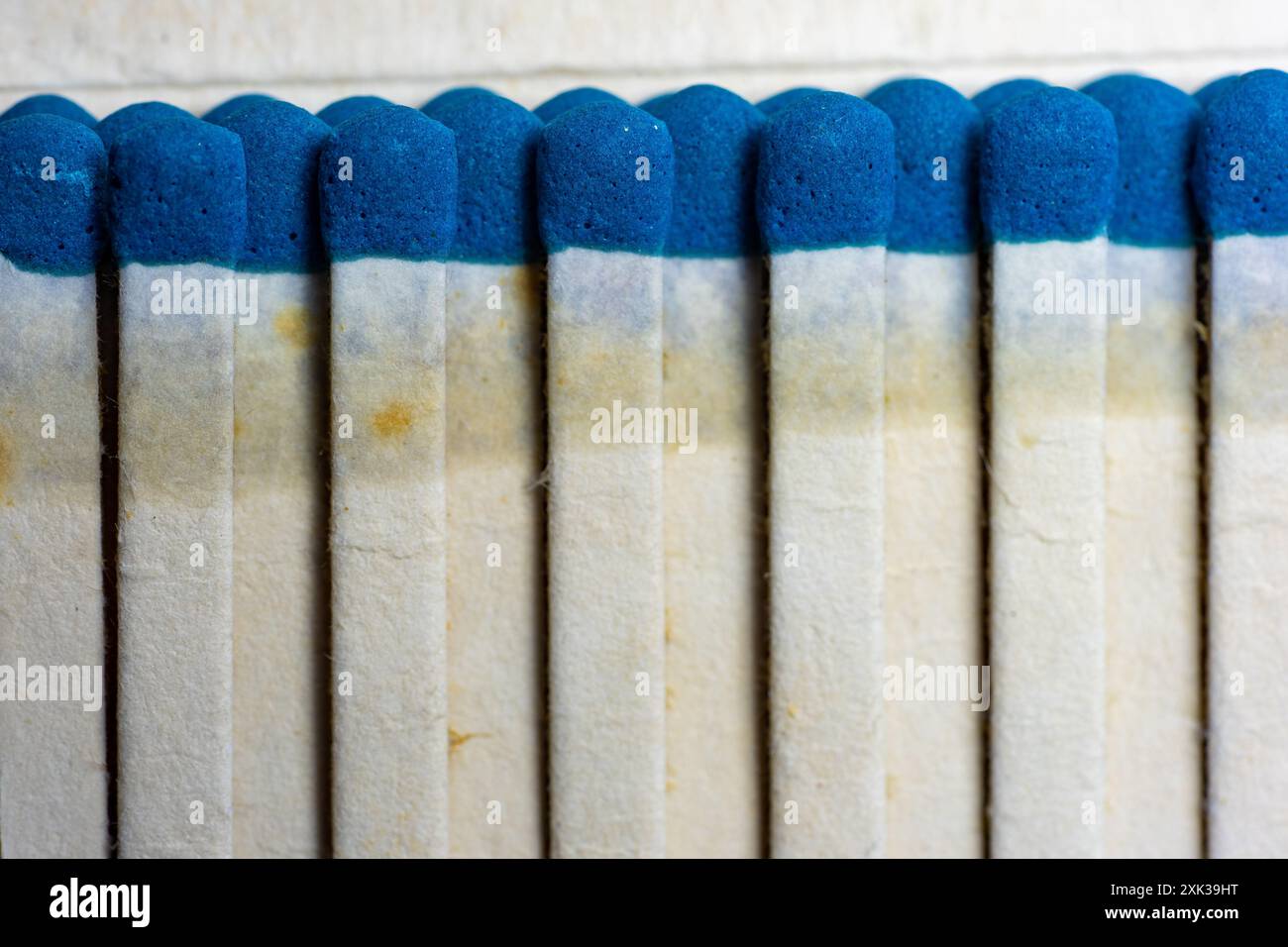 A blue match head focused on a blurred background of blue cardboard ...