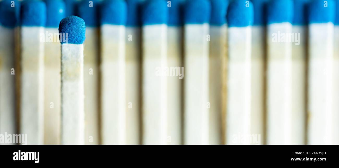 A blue match head focused on a blurred background of blue cardboard ...