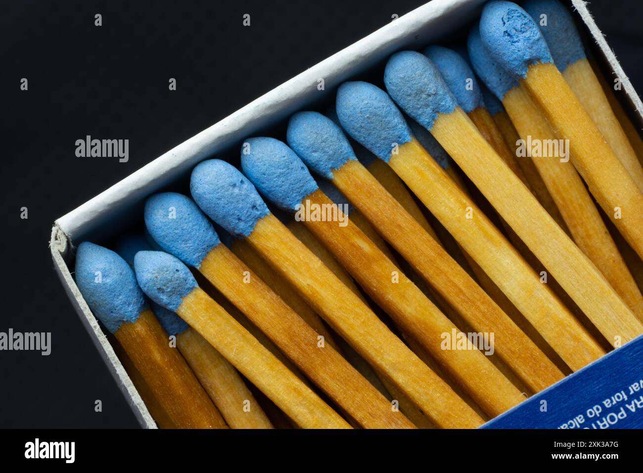 A blue match head focused on a blurred background of blue cardboard ...