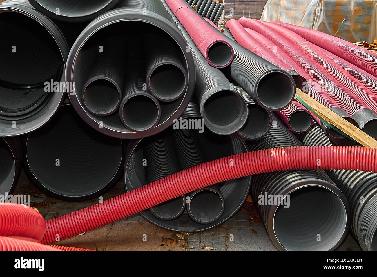 Close-up view of stacked black and red industrial pipes outdoors ...