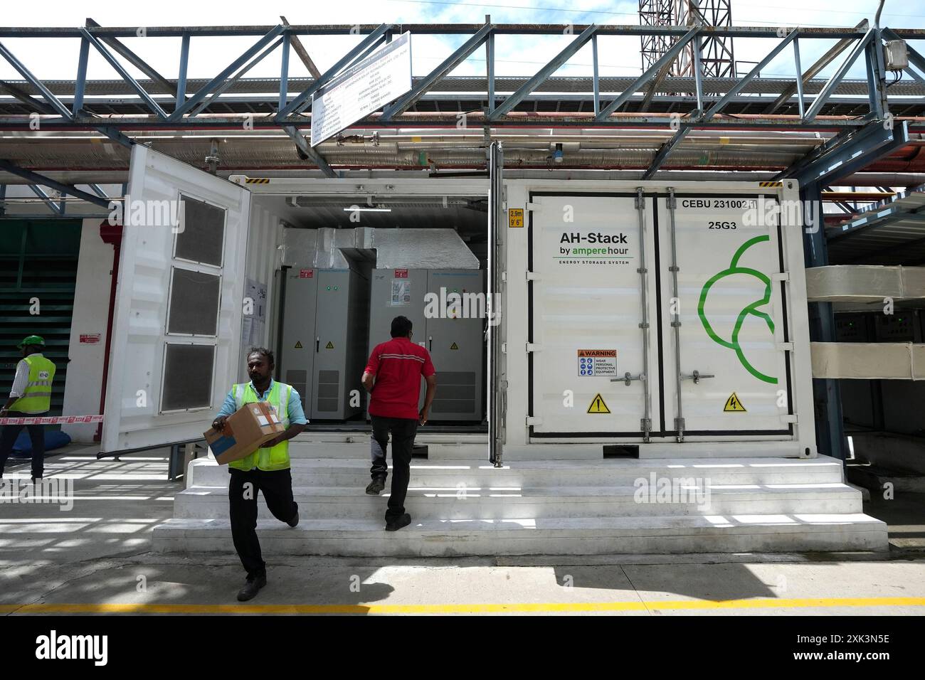 A worker walks in front of the 500-kilowatt battery energy storage ...