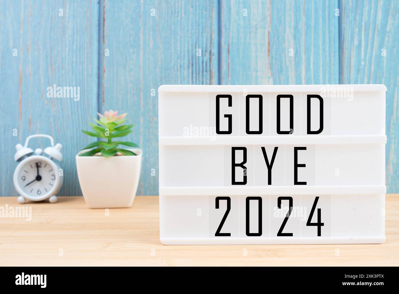 Goodbye 2024 text in light box with alarm clock on wooden table Stock ...