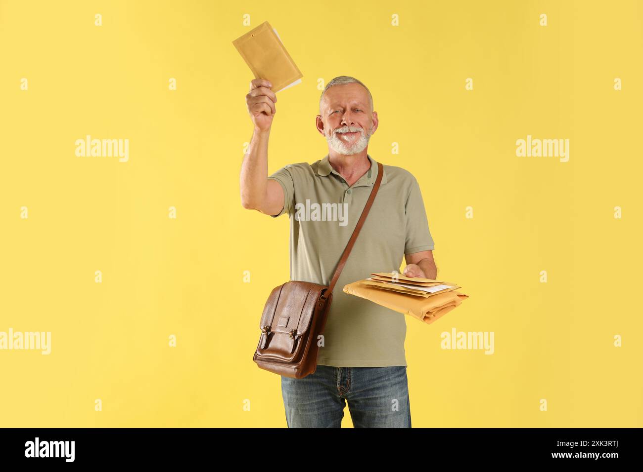 Happy postman with brown bag delivering letters on yellow background ...