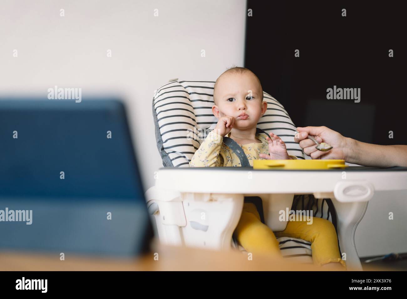 Little girl, eating his lunch, while watching cartoons on tablet Stock ...