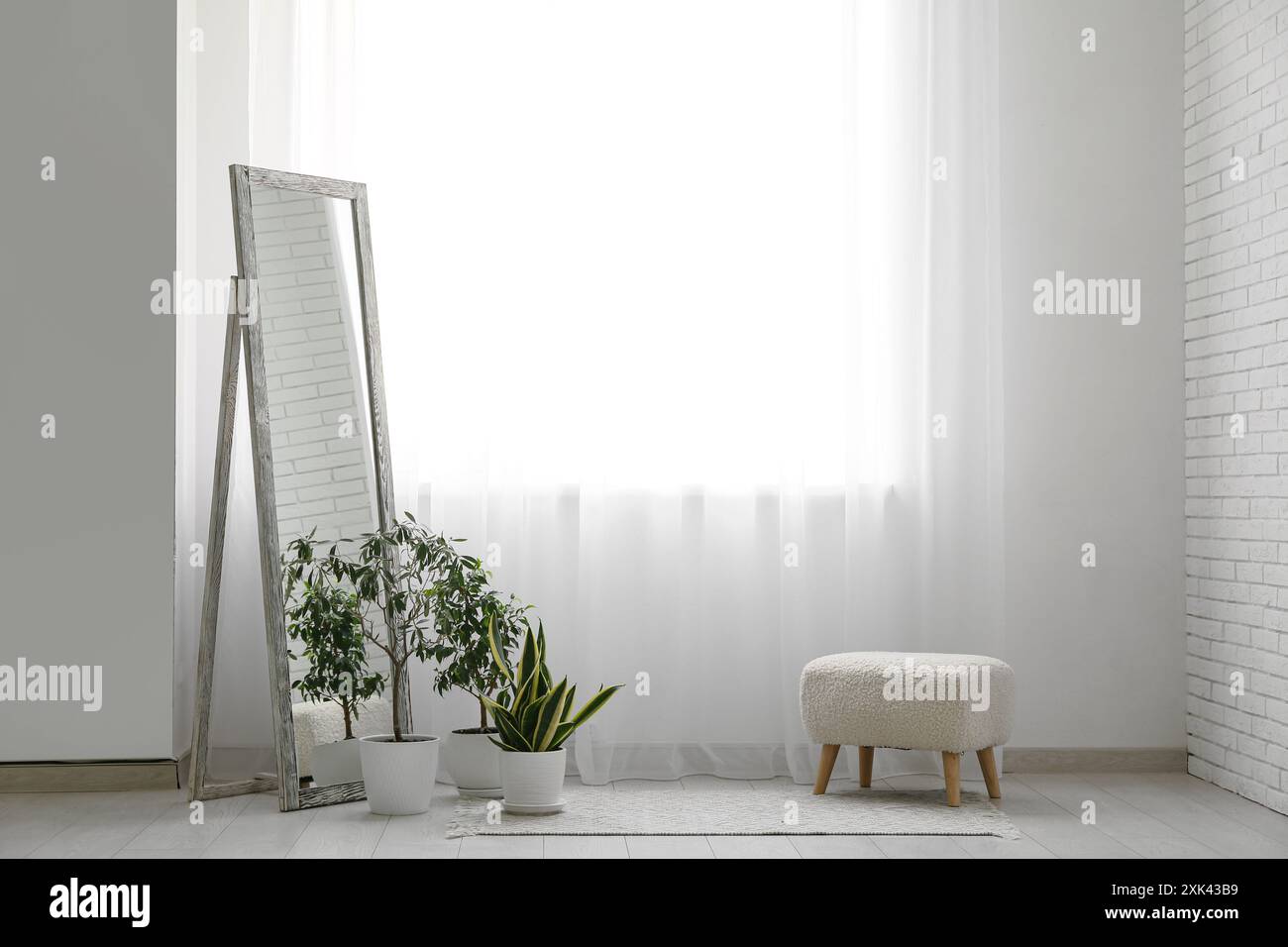 Mirror, houseplants and pouf near light curtain in room Stock Photo - Alamy