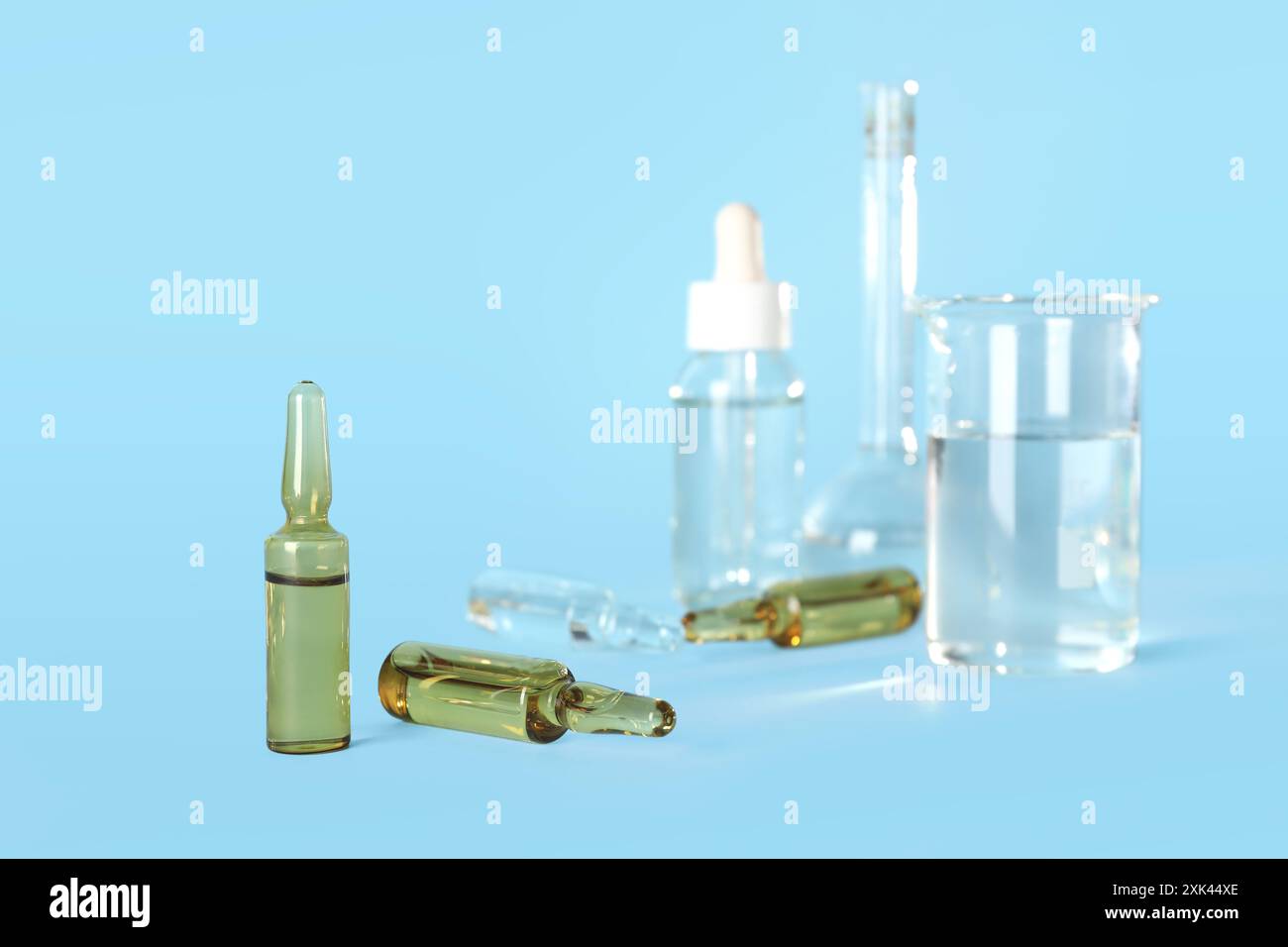 Glass ampules with flasks on blue background Stock Photo - Alamy