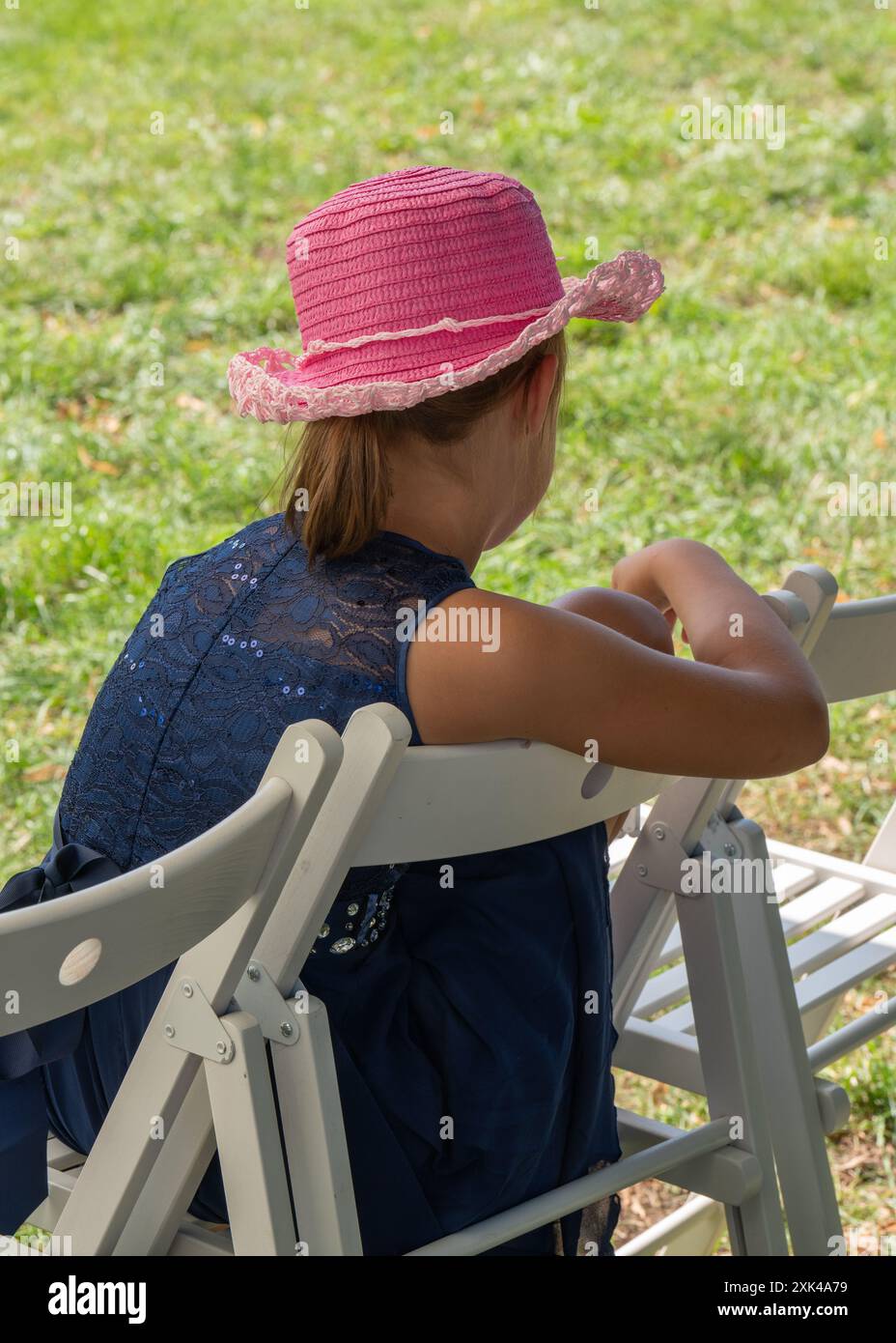 A little girl sits alone on a chair, sadness, loneliness in children ...