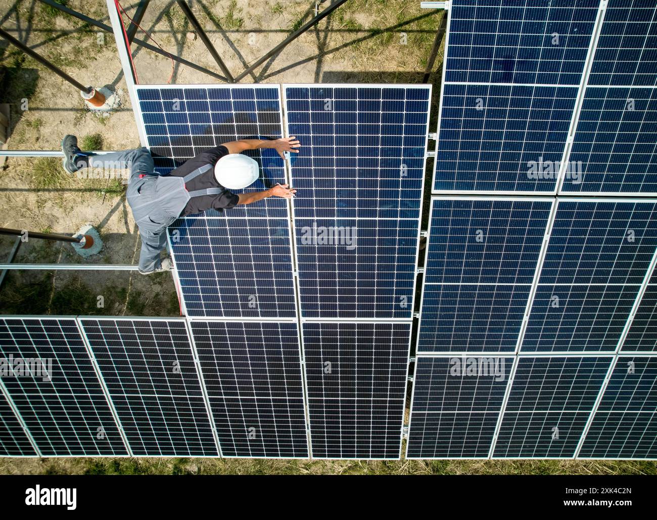 Worker installing solar panels in field at sunny day. Man wear helmet ...
