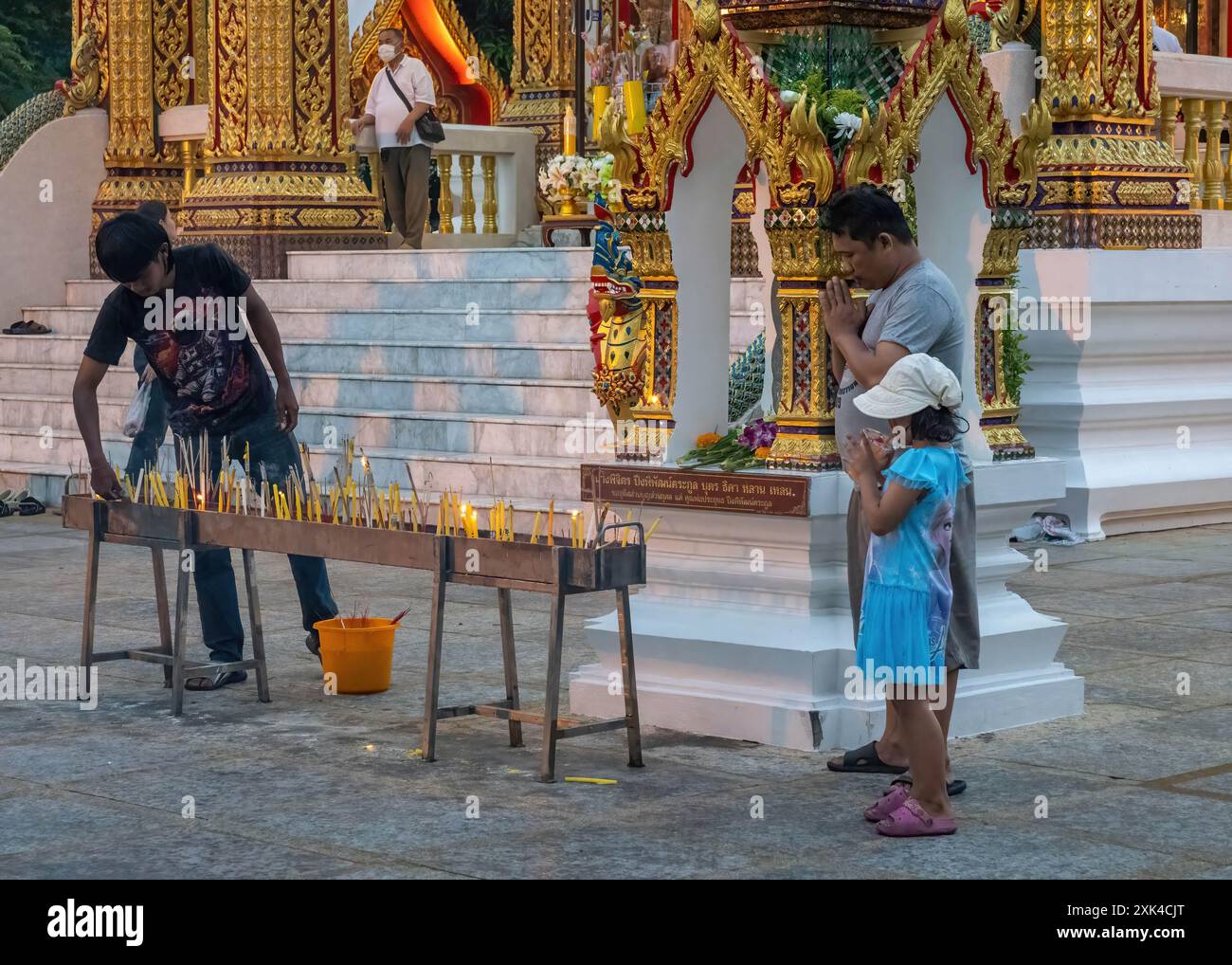 Father and daughter are seen praying after adding their lit candles ...