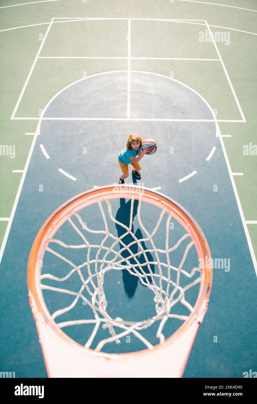 Kid playing basketball holding ball with happy face Stock Photo - Alamy