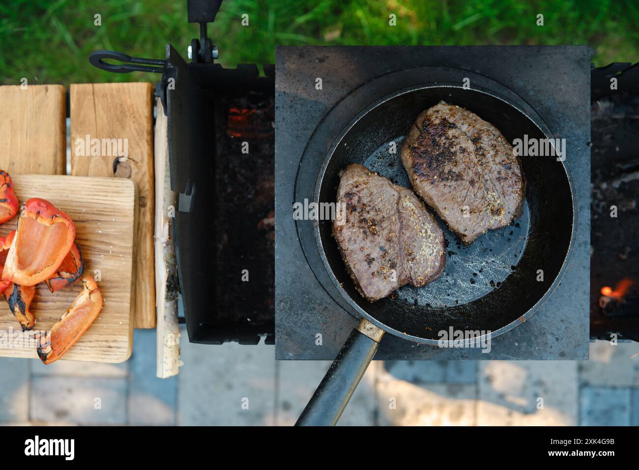 Overhead view of two pieces of beef steak in a frying pan on outdoor ...