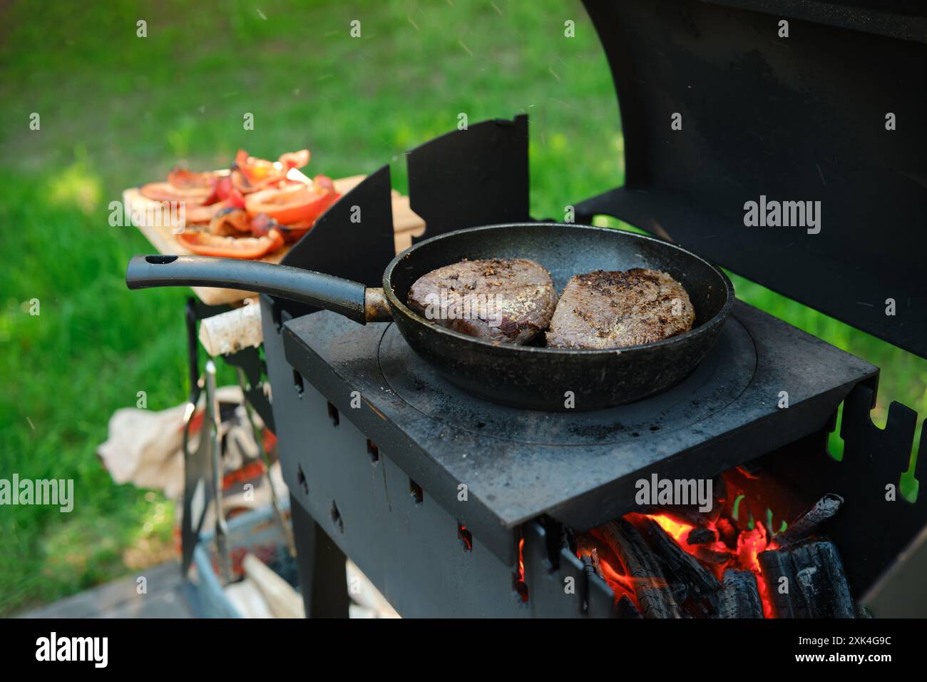 Frying beef steak in a griddle pan on outdoor grill Stock Photo - Alamy