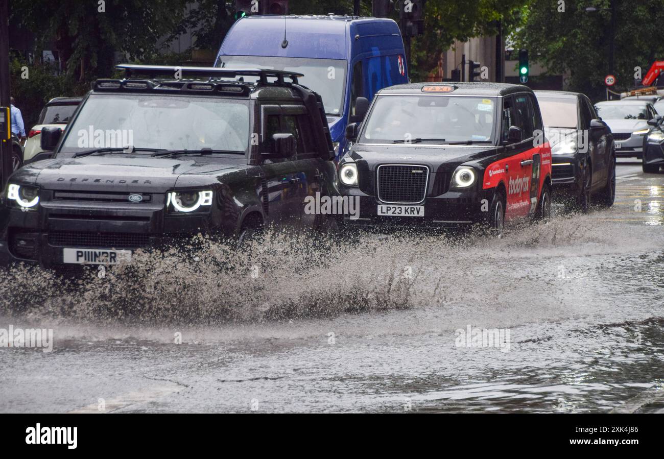 London, UK. 9th July 2024. Cars splash through a waterlogged Euston ...