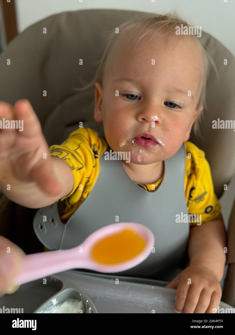 Baby eating his food with hands and spoon Stock Photo - Alamy