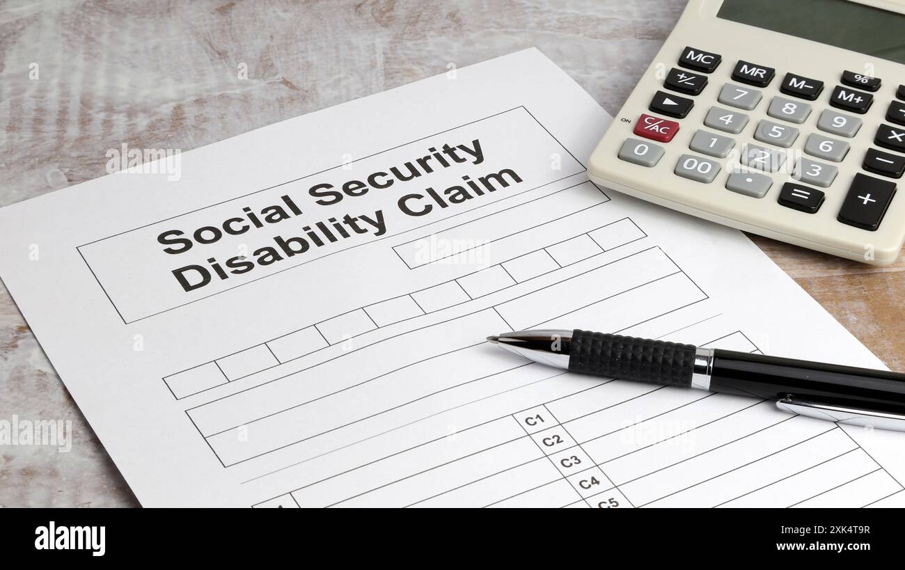 Disability claim form social security, desk with calculator and pen ...