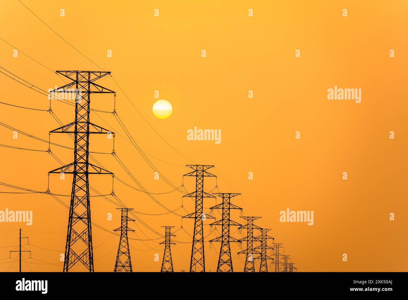 Electricity pillars against a colorful yellow sunset. Silhouette high ...