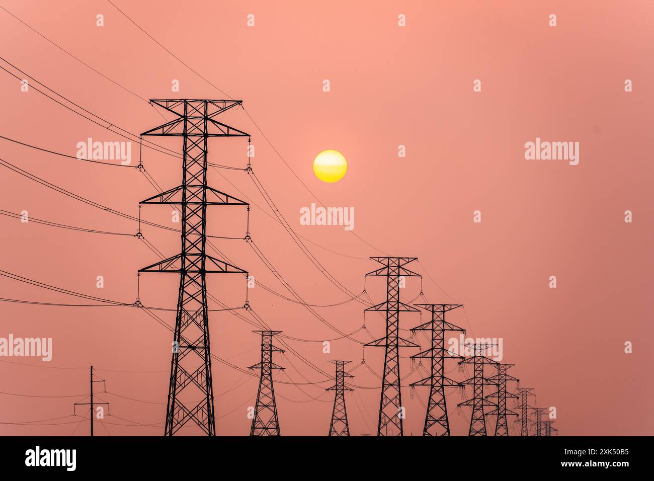 Electricity pillars against a colorful yellow sunset. Silhouette high ...