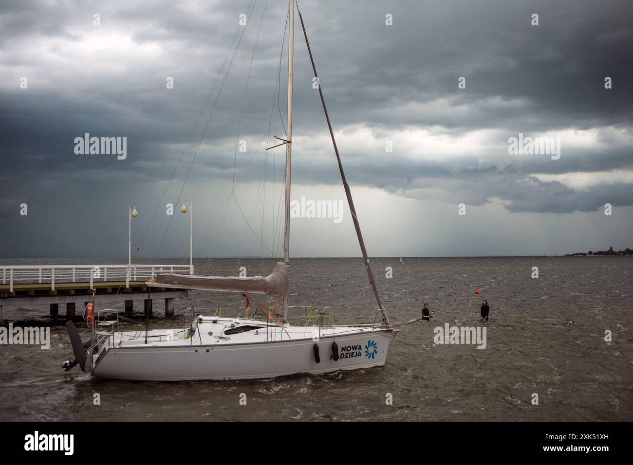 Jurata, Poland. 10th July, 2024. Two men try to moor a sailboat at the ...
