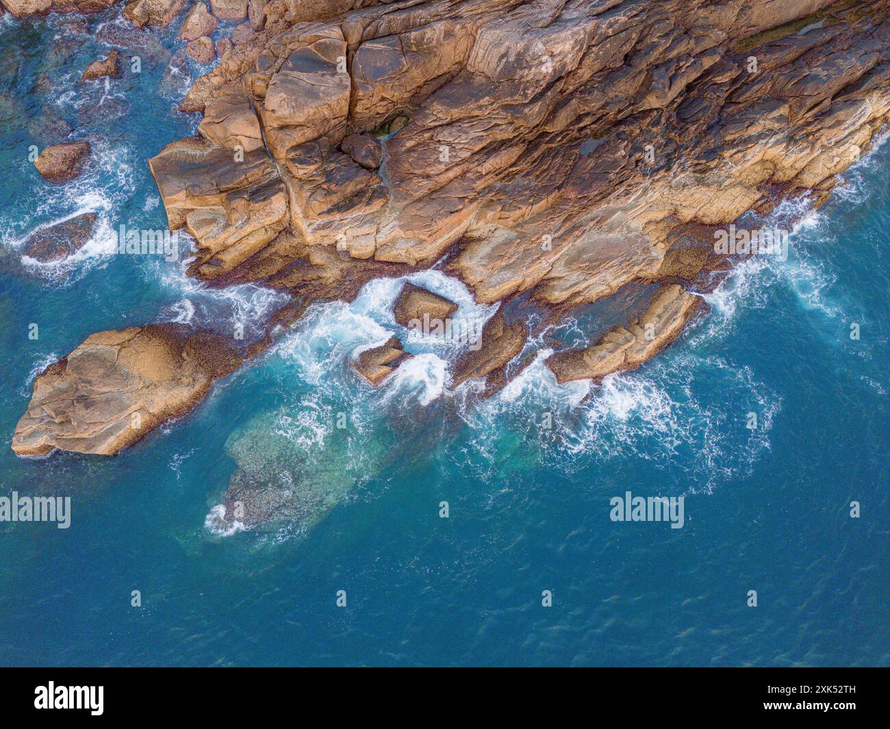 Aerial drone top view of beautiful waves crashing on the rocky island ...