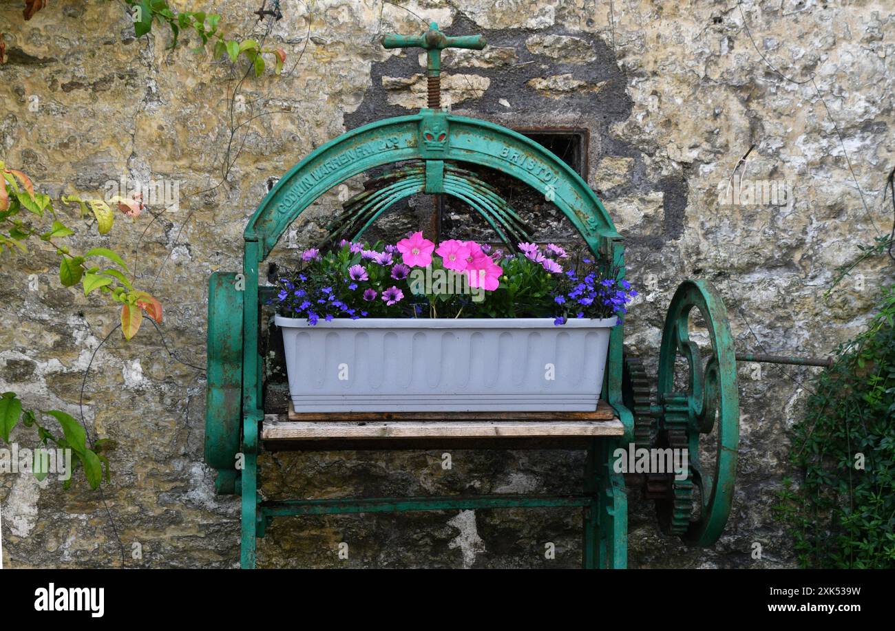 An old washing mangle used as a holder for a trough of flowers in an ...
