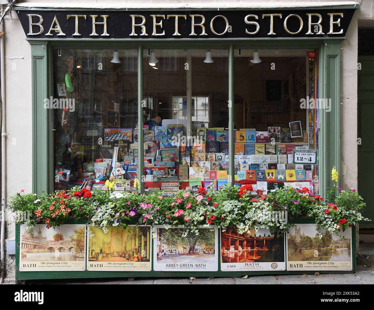 A colourful shopfront in Bath with posters of the city, a long window ...