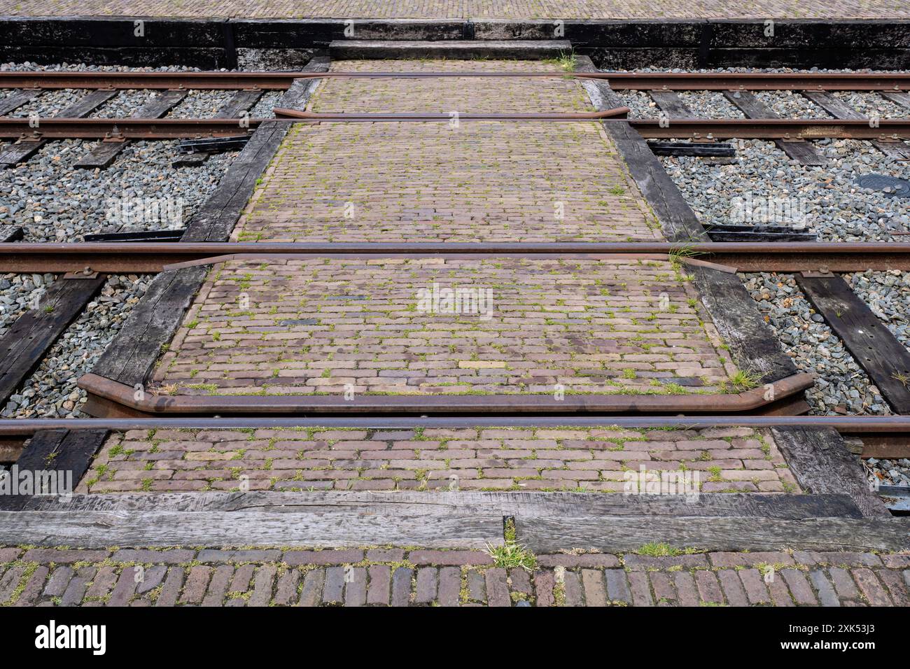 walkway out of cobblestones over rails Stock Photo - Alamy