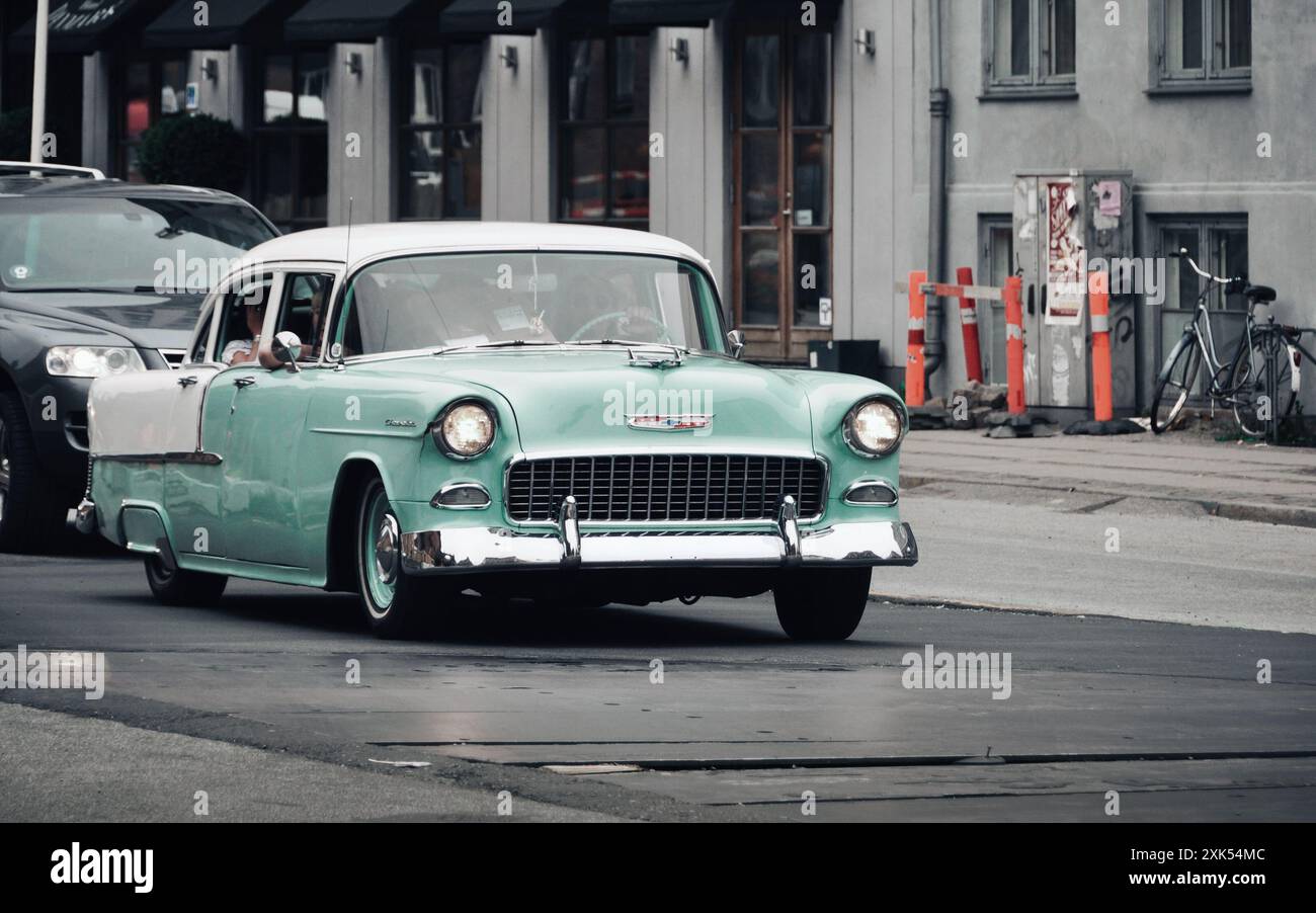 Turquoise 1955 Chevrolet Bel Air driving along the street. Front three ...