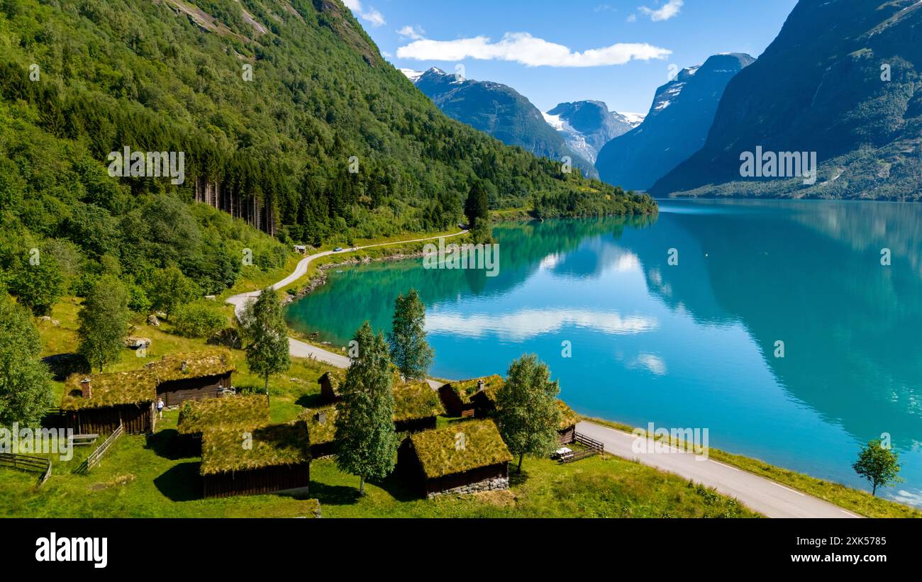 Traditional Norwegian cabins with grass roofs nestled by a serene fjord ...