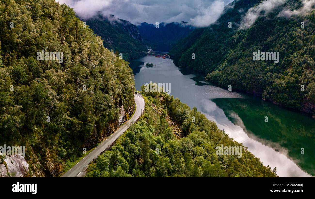 A winding road carves through a lush, forested landscape, offering ...