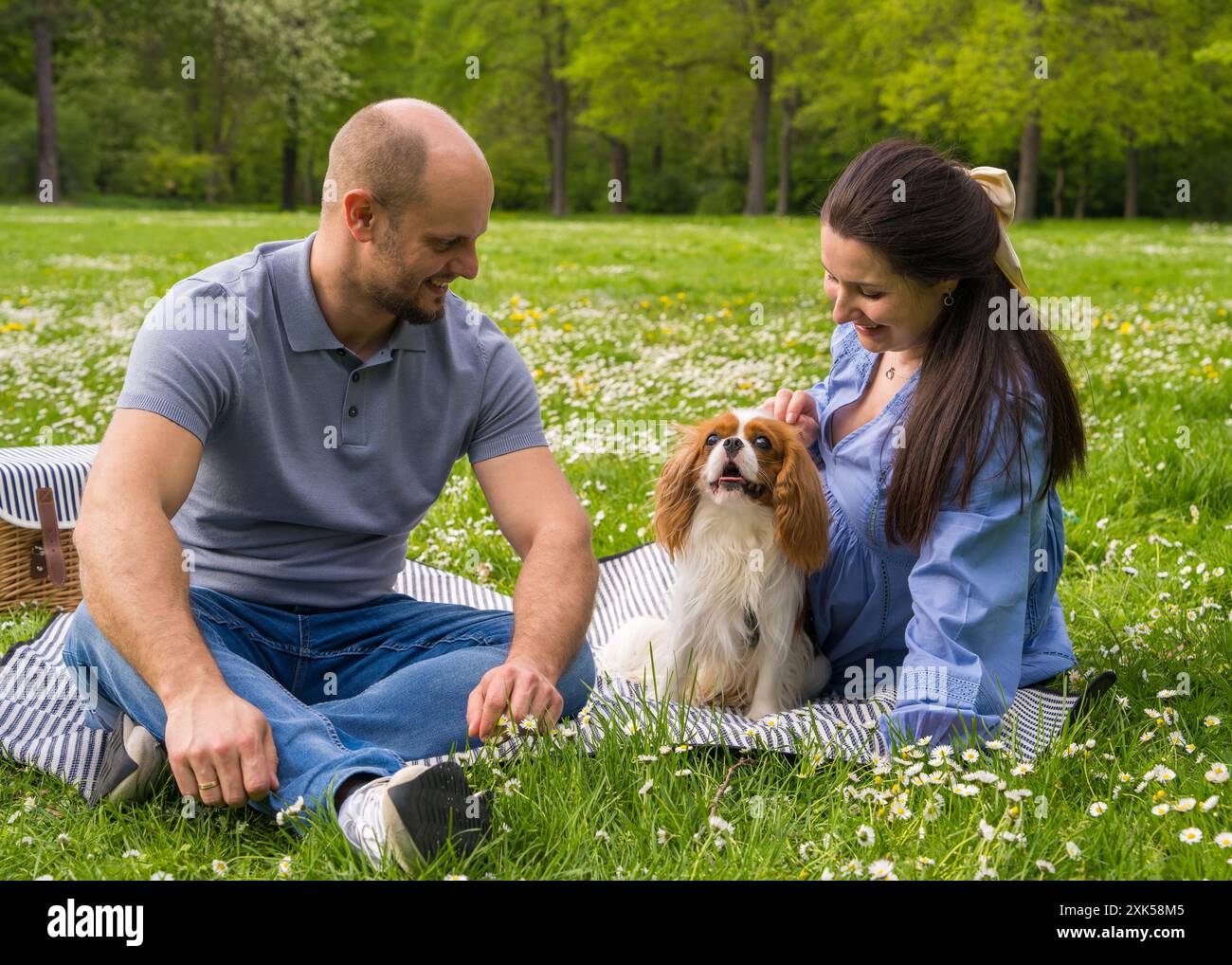 Happy pregnant couple spends time together on a picnic outdoors with a ...